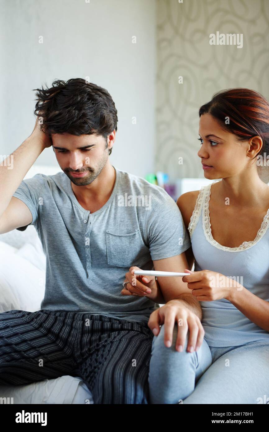 Oh boy. Overwhelmed couple reading a pregnancy test Stock Photo - Alamy