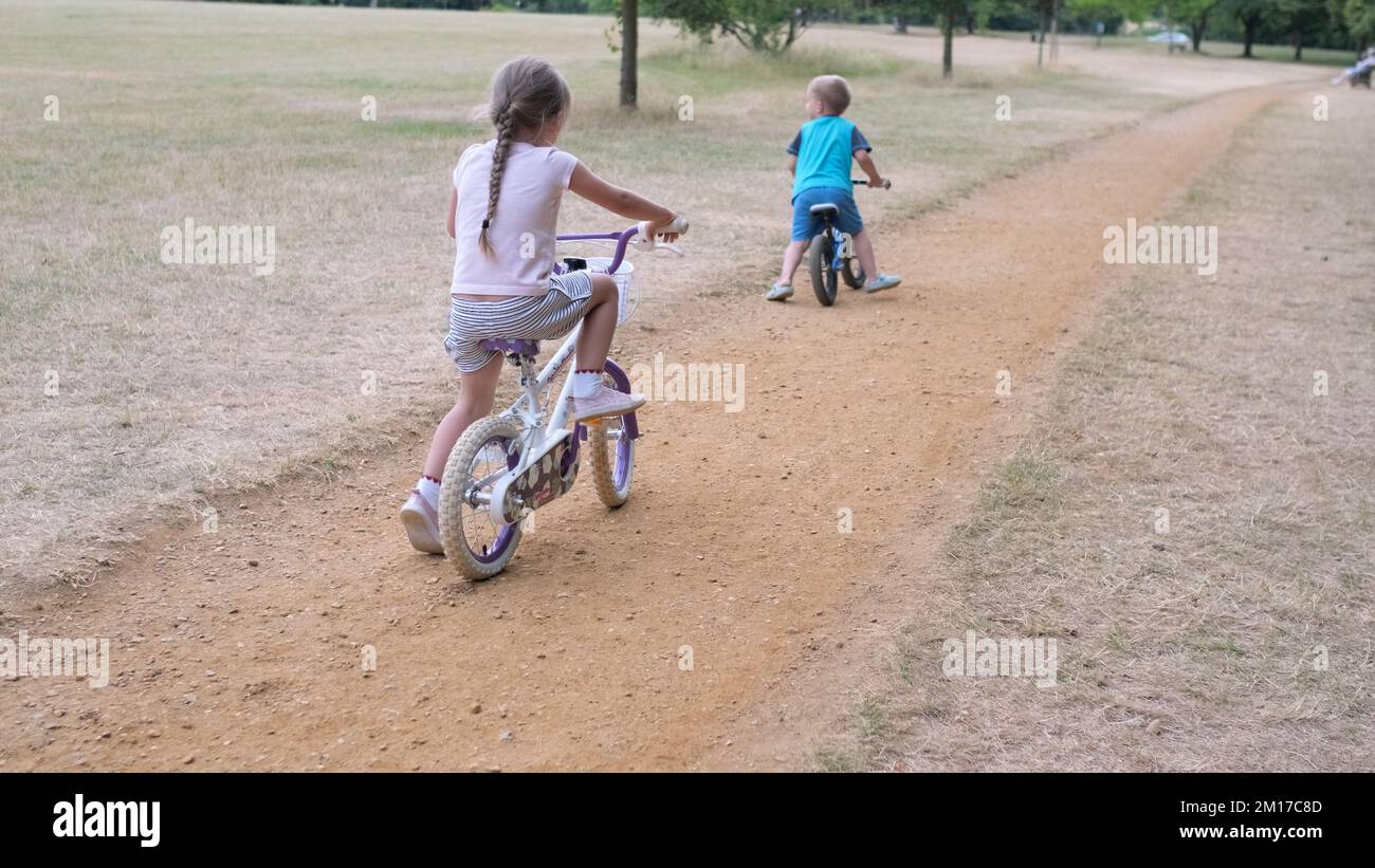 Sport activity for children. Small kids playing bicycle and scooter ...