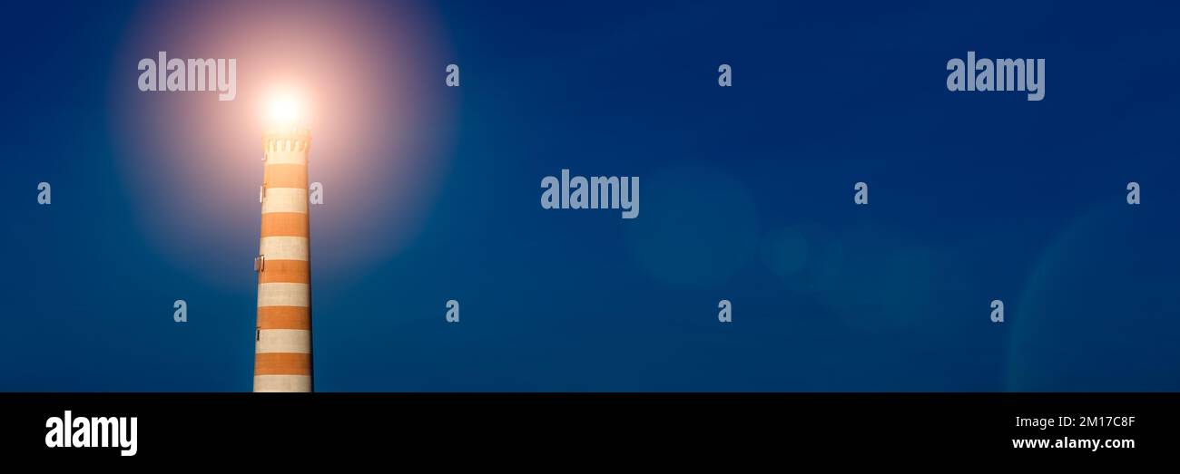 View of the old striped lighthouse beacon that shines brightly in the ...