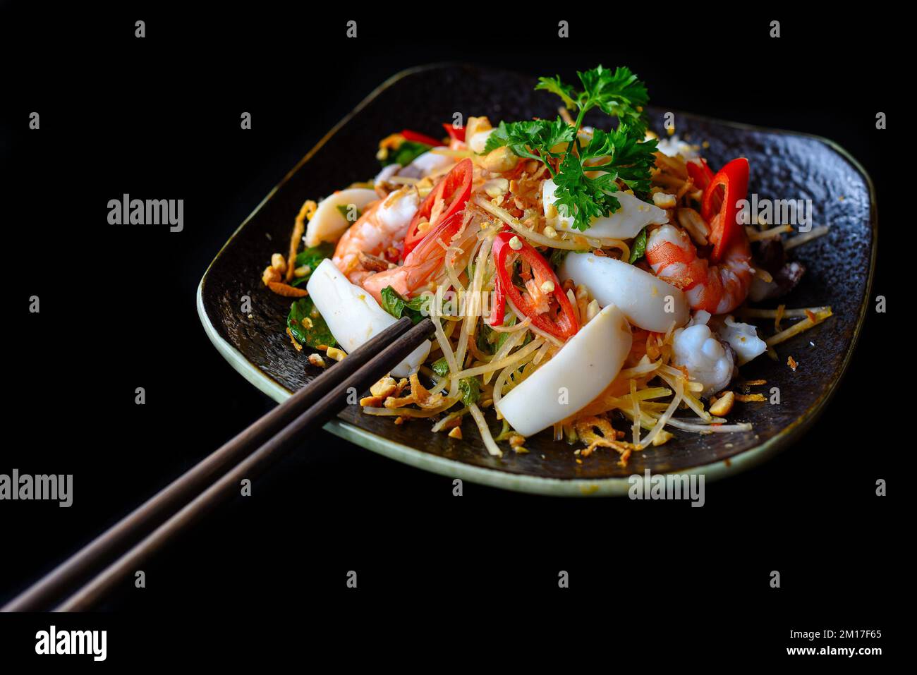 Salad made of shrimps and squid isolated on black background side view ...