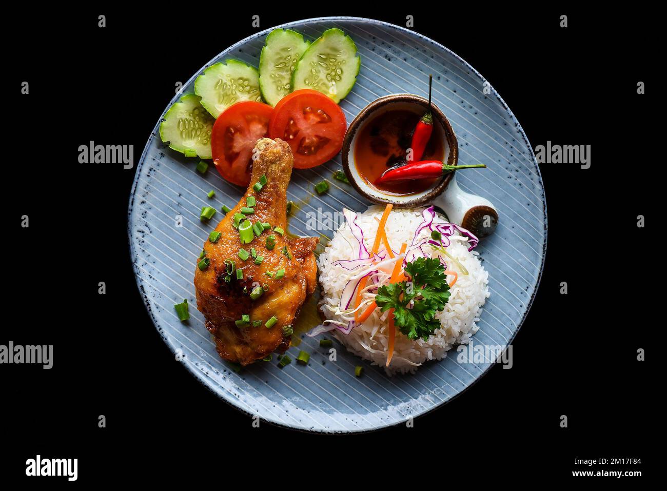 Roasted chicken leg in Vietnamese style with rice, vegetables and sauce ...