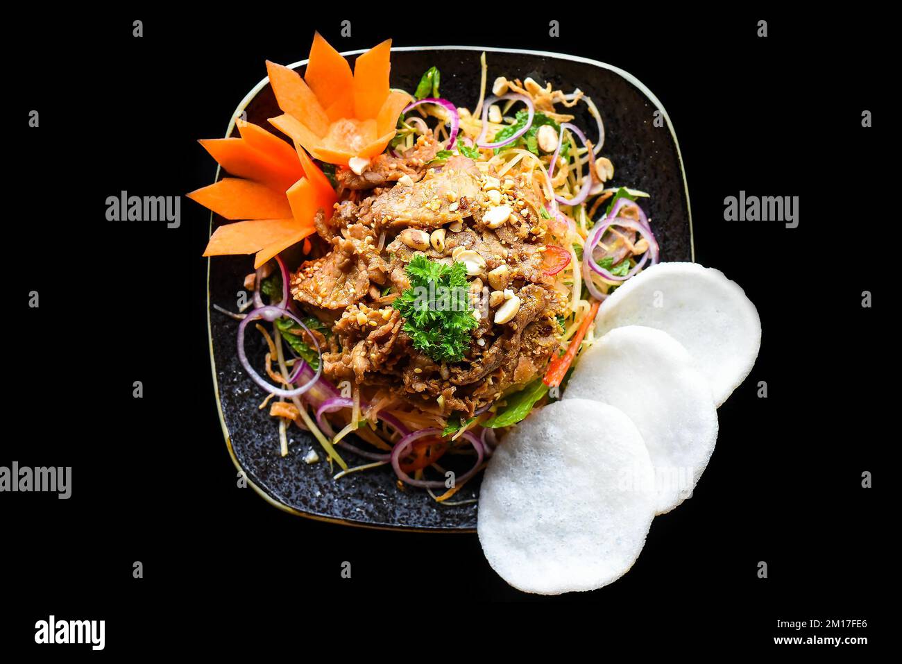 Asian beef salad with green papaya served with rice chips isolated on ...