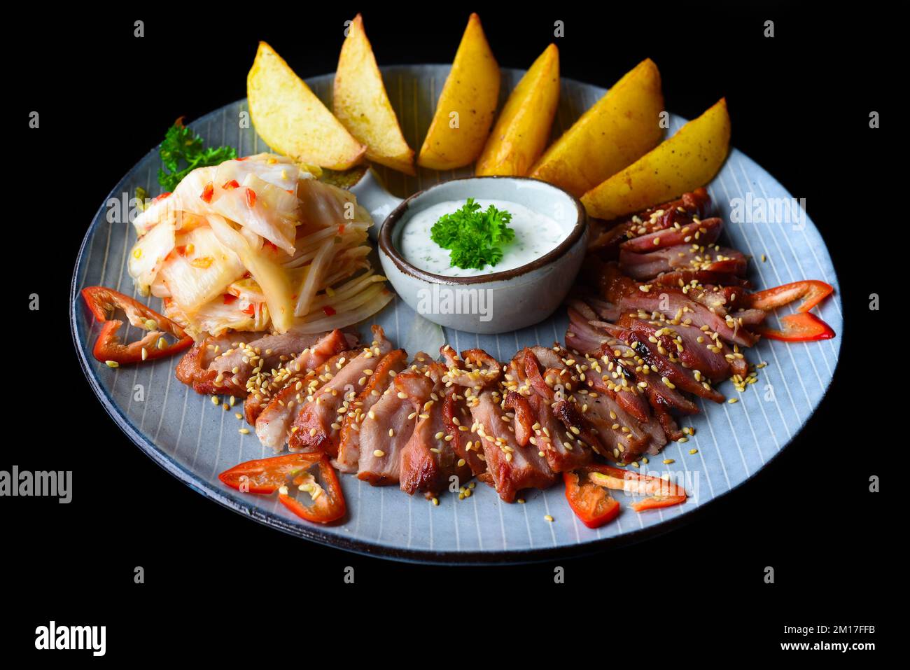 Goose fillet fried with garlic served with potato wedges and kim chi on ...