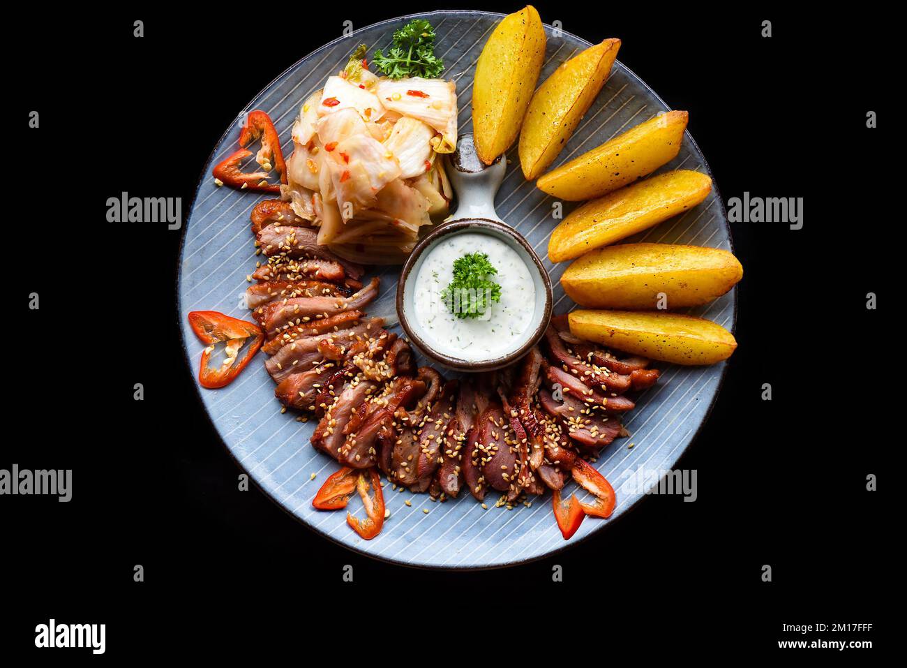 Goose fillet fried with garlic served with potato wedges and kim chi on ...