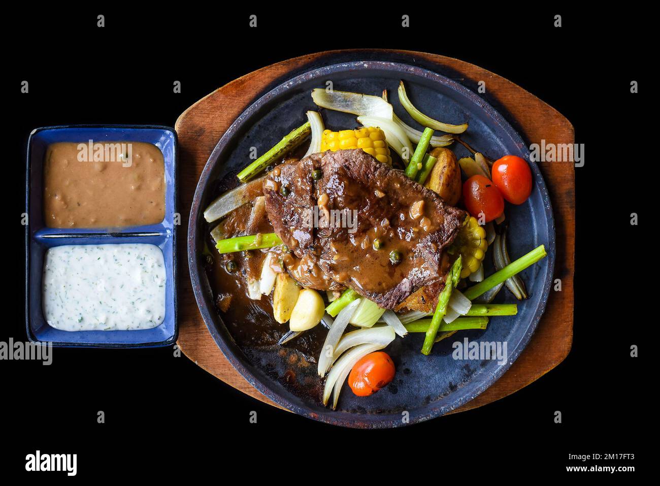 Roasted fire beef steak with vegetables and greens on plate isolated on ...