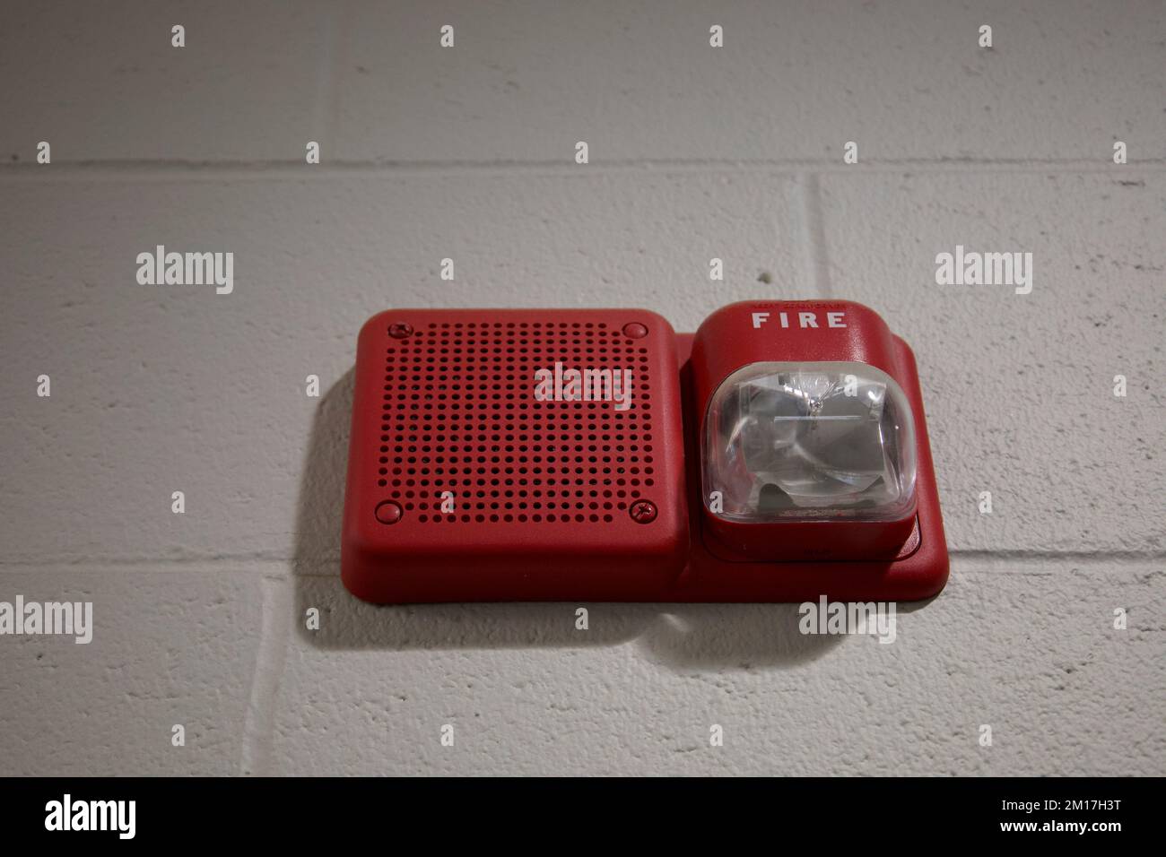 Red fire alarm box with white light in American school building ...