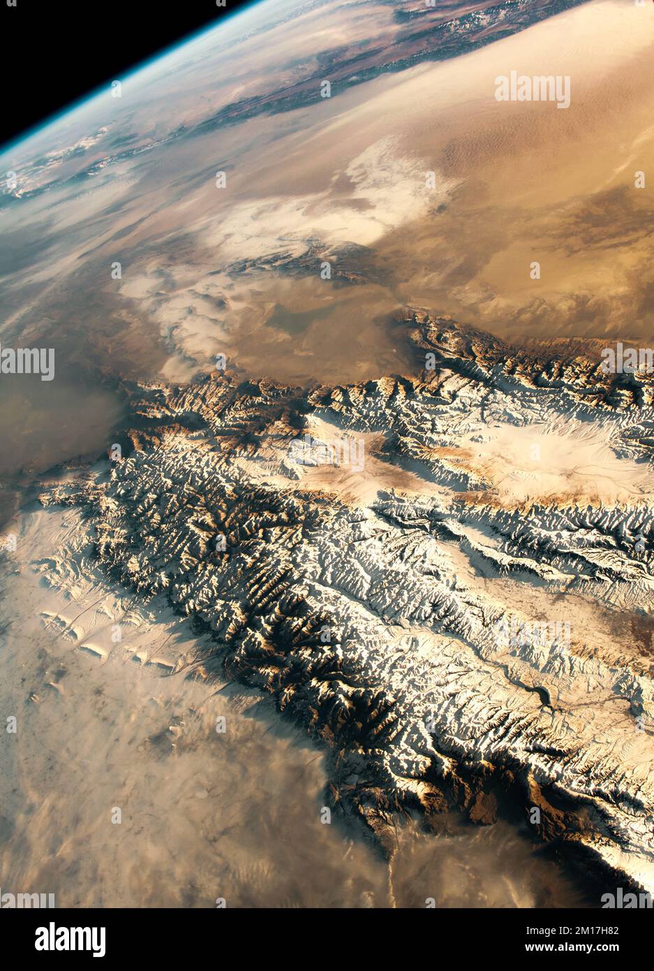 Aerial view of Tien Shan Mountains covered in snow and sand in central ...