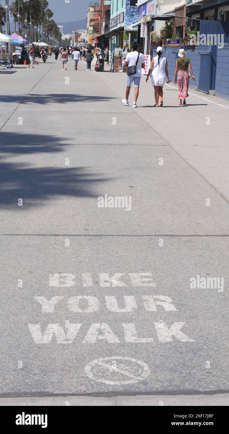 Walk Your Bike sign written on the asphalt on the boardwalk in Venice ...