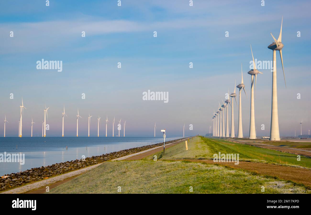 windmill turbines during winter generating electricity with a blue sky ...