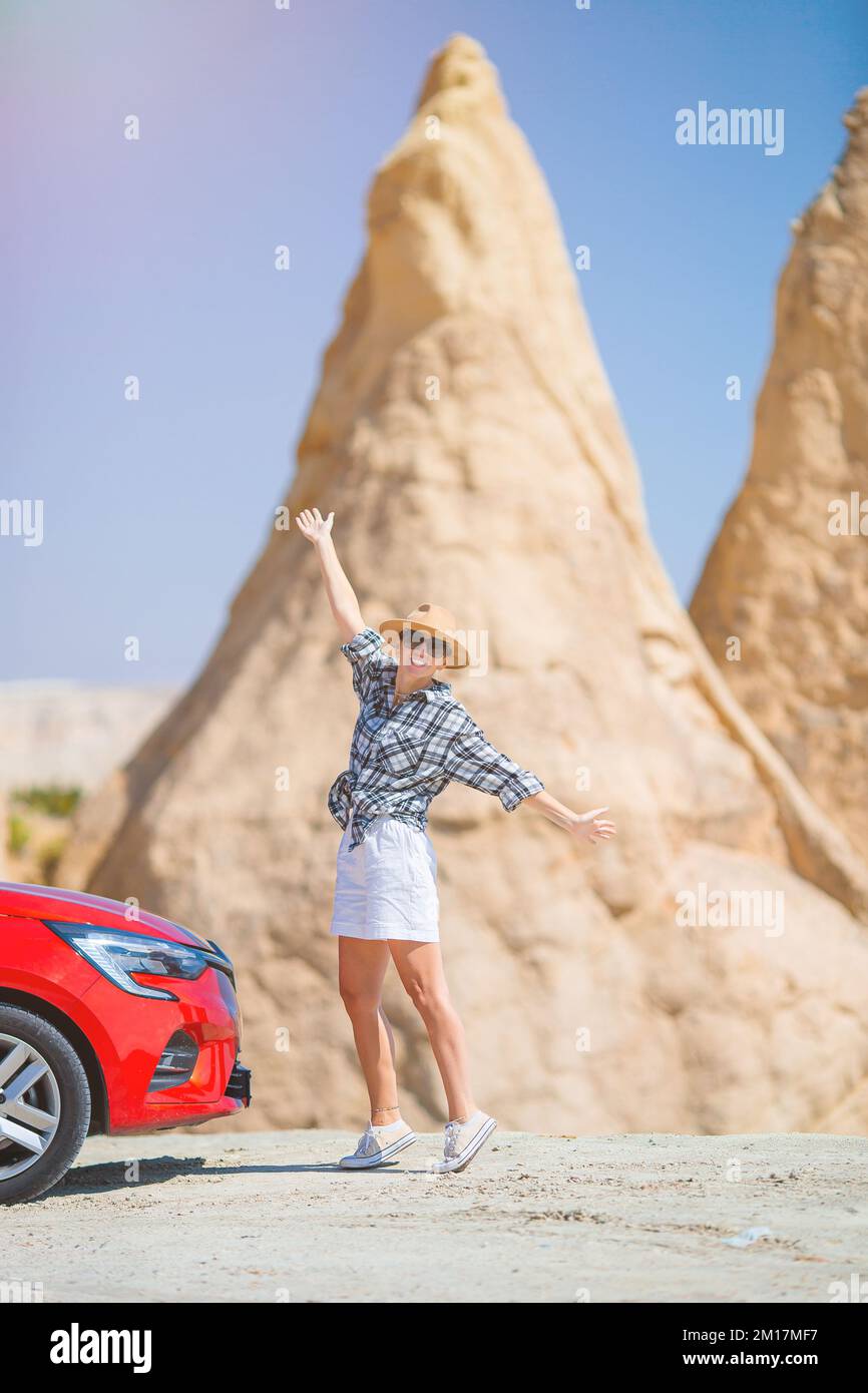 Young happy woman on vacation by car in Cappadocia. Cave formations ...