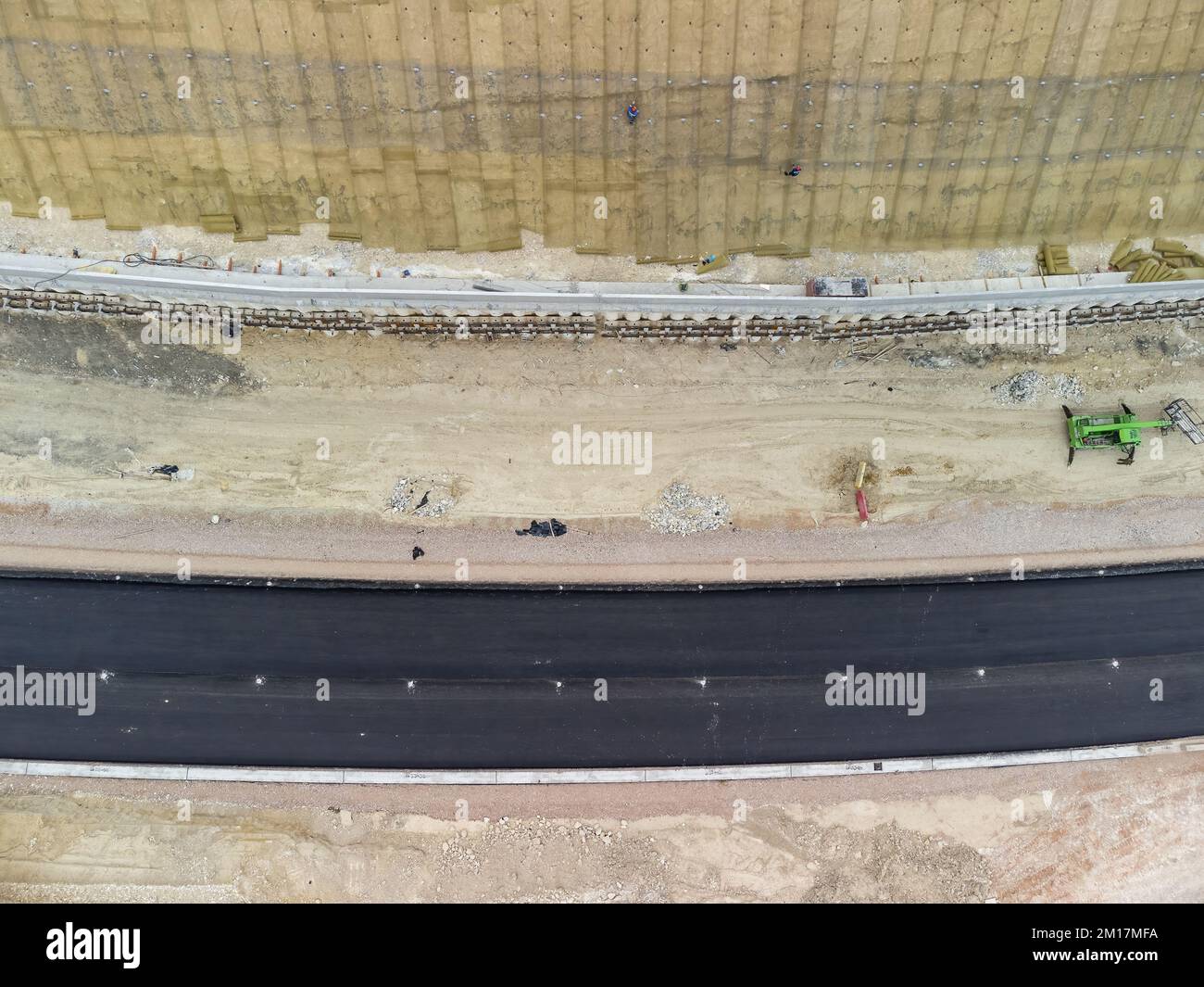 Mountain road constraction. Workers reinforce the slope over the new ...