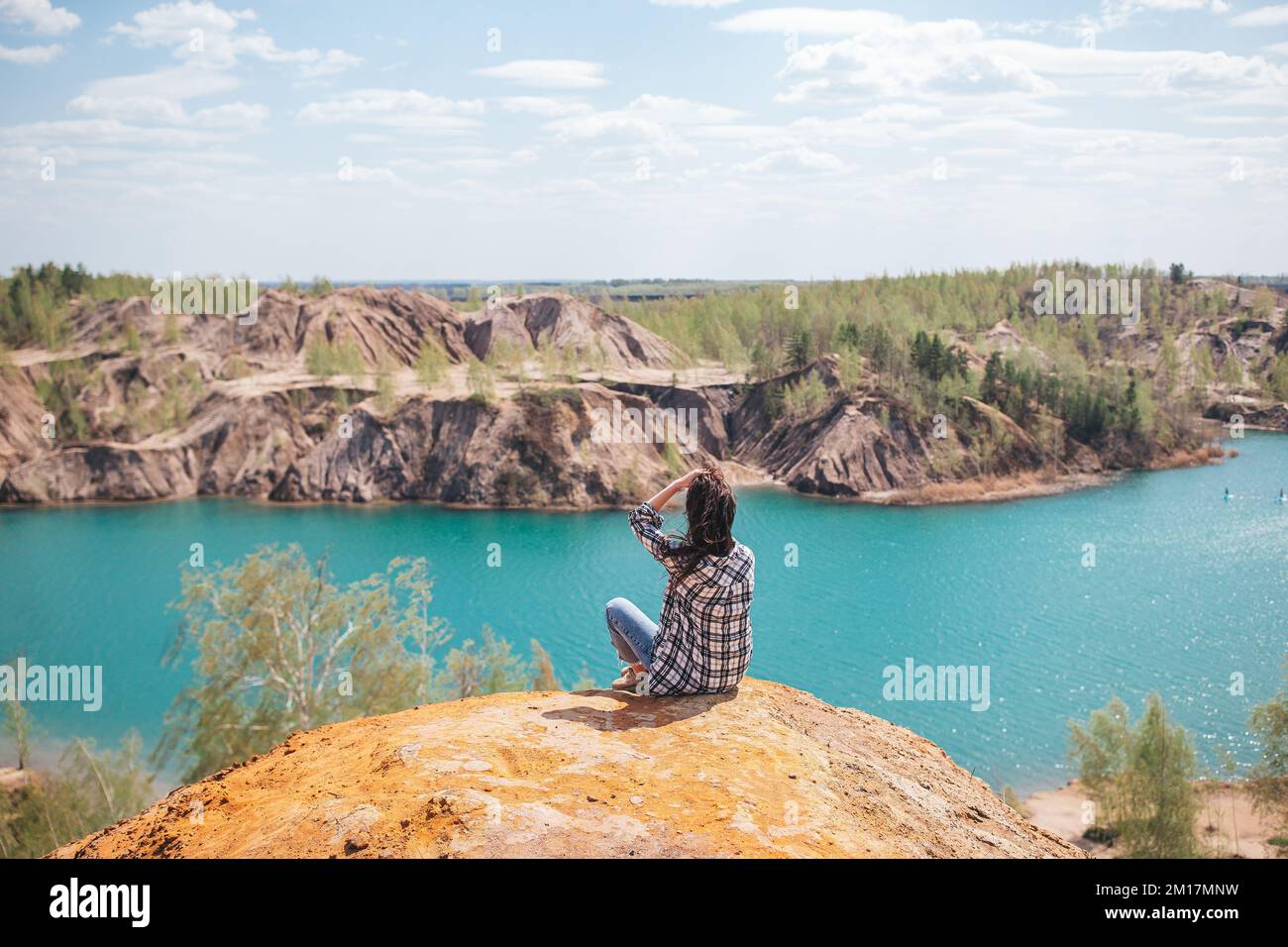 Young woman sitting on the top of mounting and feeling free and looking ...