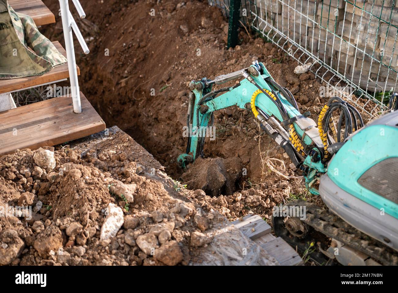 Mini excavator digs a trench to lay pipes. Close up of an excavator ...