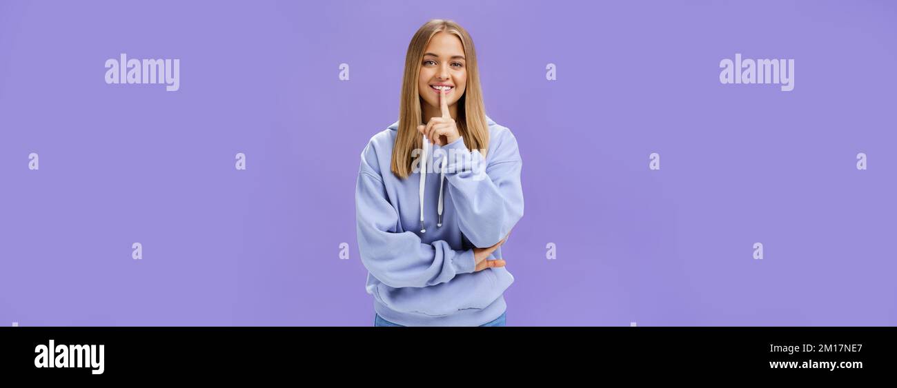 Portrait of joyful cute feminine young woman in hoodie smiling happily ...