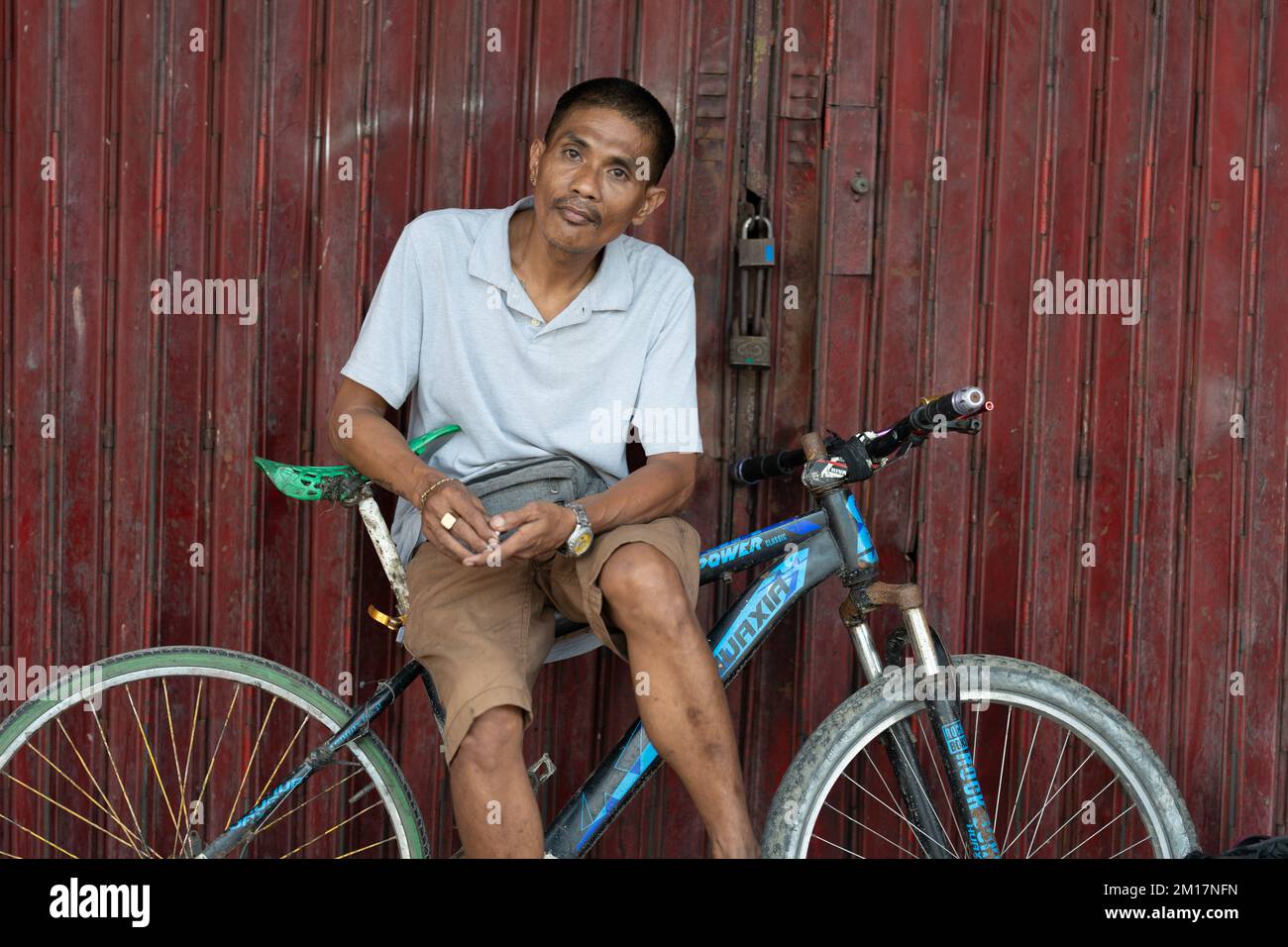 Environmental Street Portrait of a Filipino man sitting on a bicycle ...