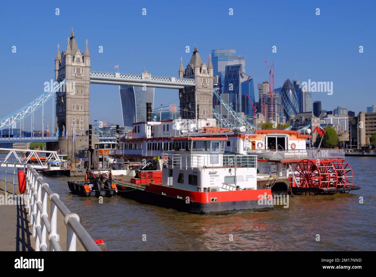 Tower Bridge across the Thames with city skyline and colourful red and ...