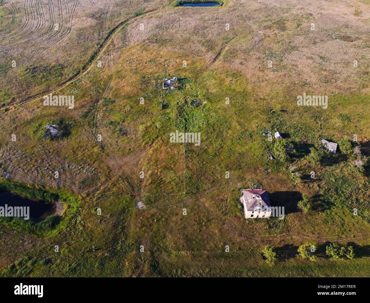 A bird's eye view of an abandoned farmhouse in the prairies of ...