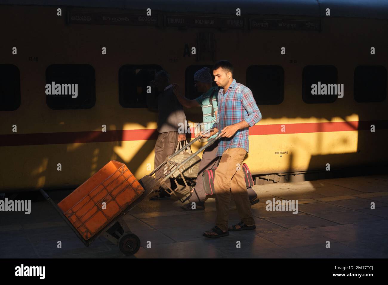 A porter with his trolley passing the carriage of a long-distance train ...
