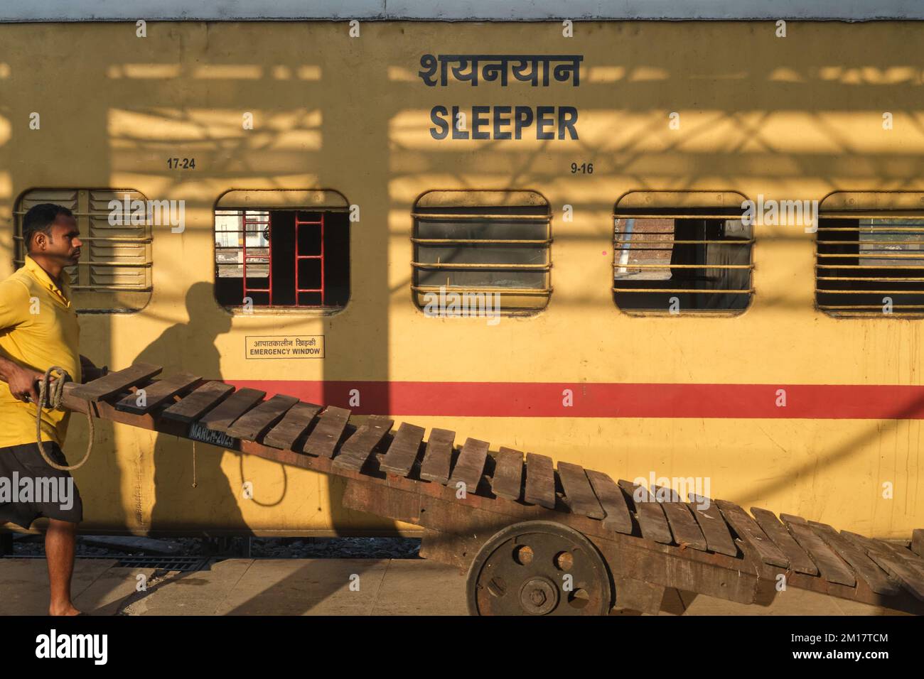 A porter with his trolley passing the sleeper carriage of a long ...
