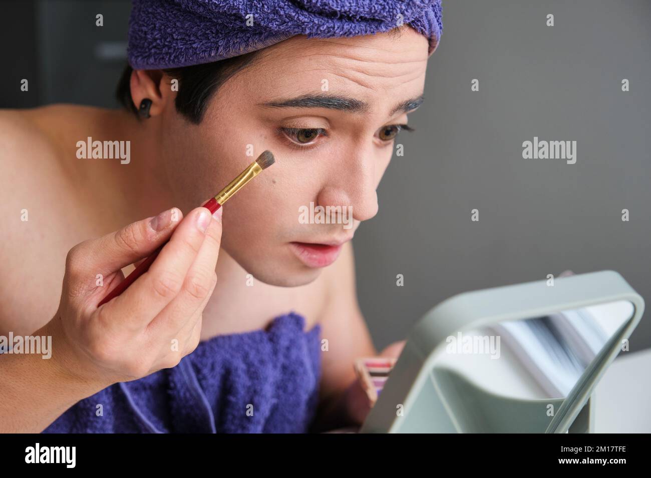 Young transgender man applying eyeshadow Stock Photo - Alamy