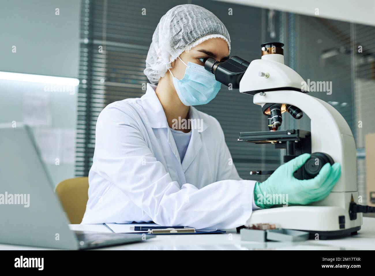 Side view portrait of young woman as female scientist working in ...