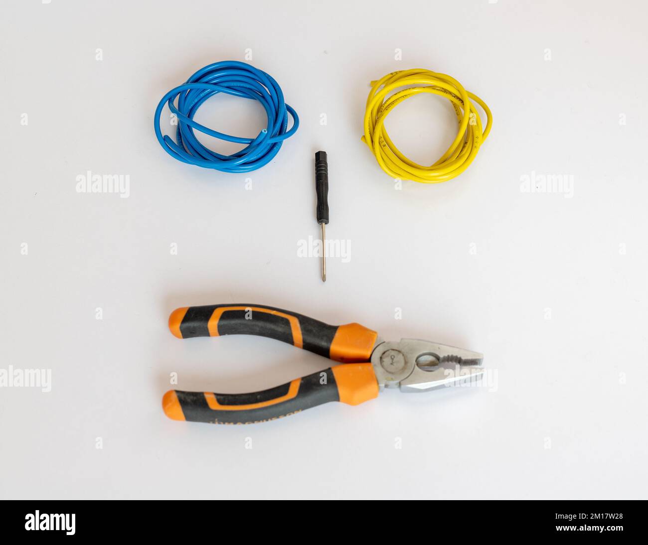 Blue and yellow color cables with tools on white isolated background ...
