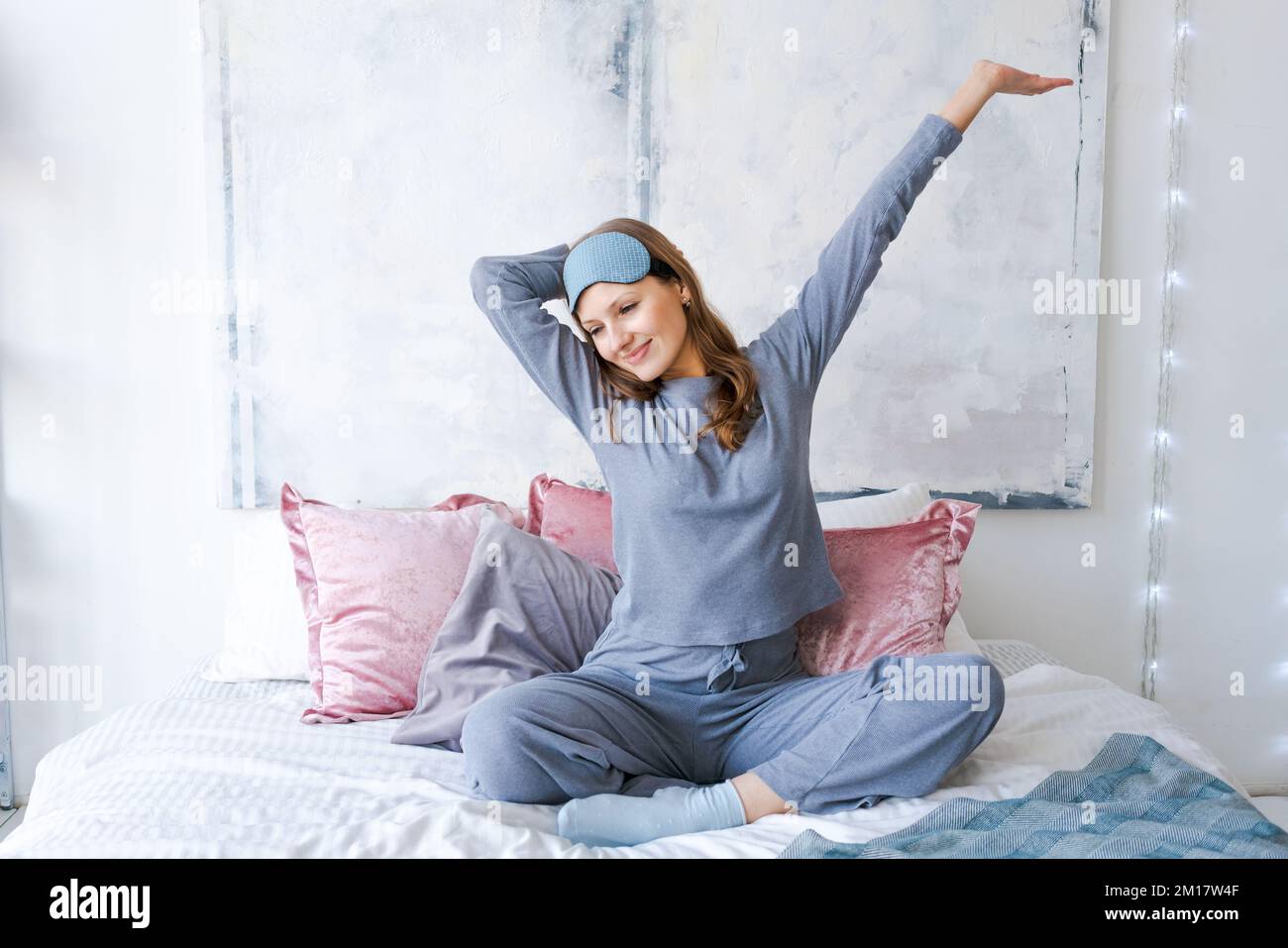 Happy healthy, beautiful young woman wearing sleep mask and blue ...