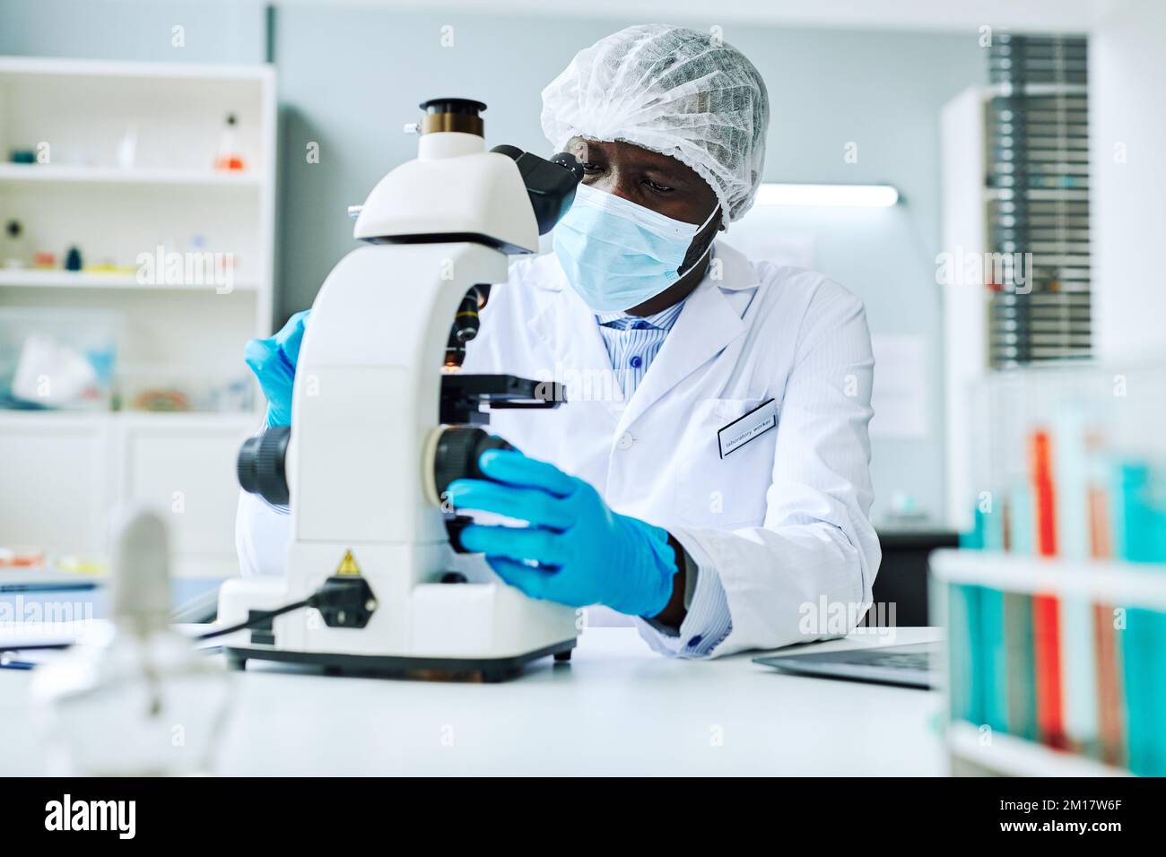 Portrait of African American man using microscope while doing research ...
