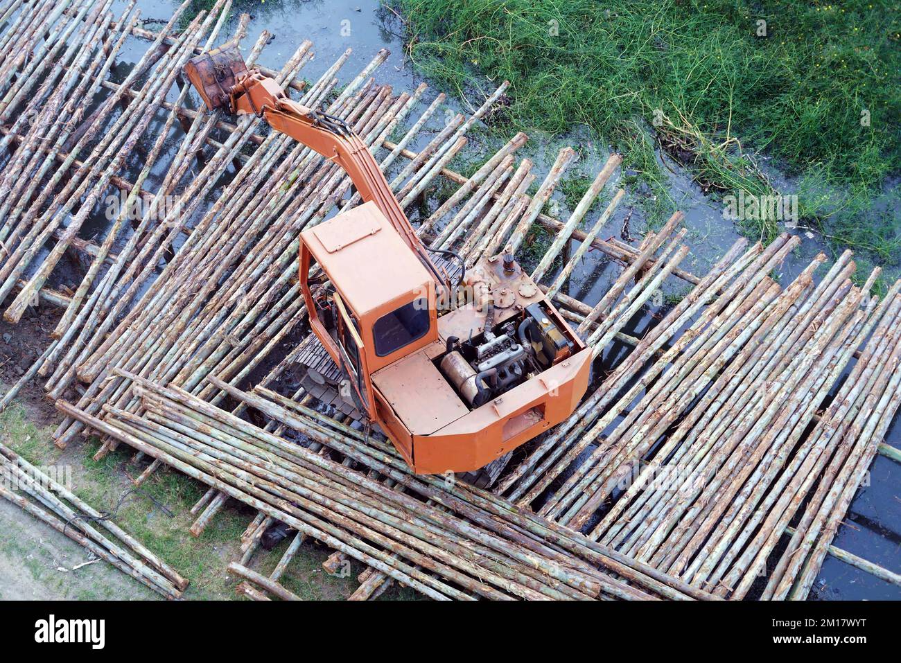 The old excavator on the wooden scaffolding on the pool preparing to ...