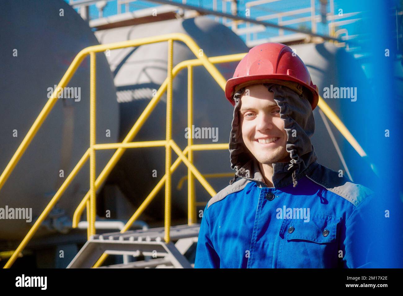 Portrait of young Caucasian man in construction helmet and work clothes ...