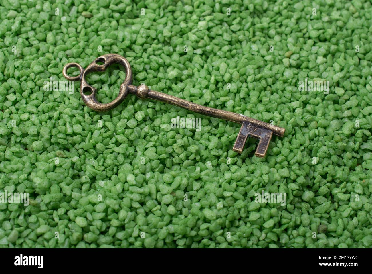 Retro style gold color key on green sand Stock Photo - Alamy