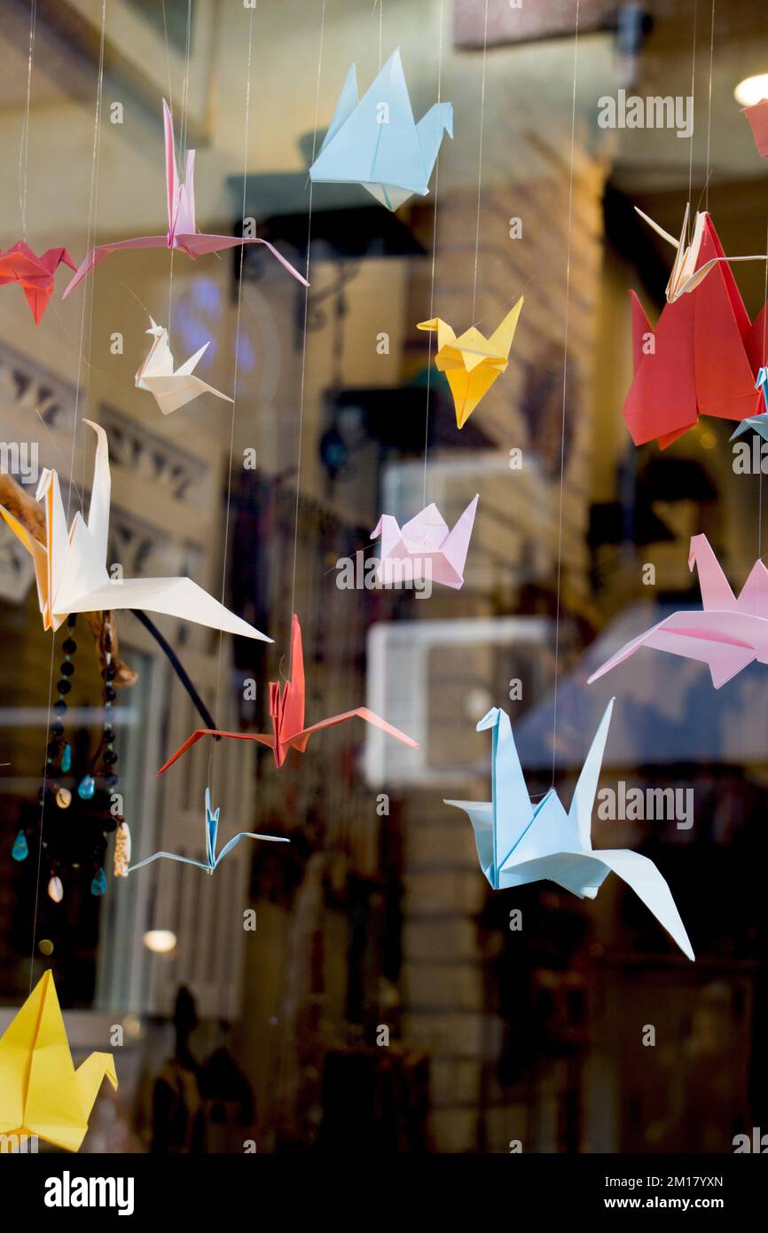 Colorful paper origami birds tied to strings hanging in air Stock Photo ...