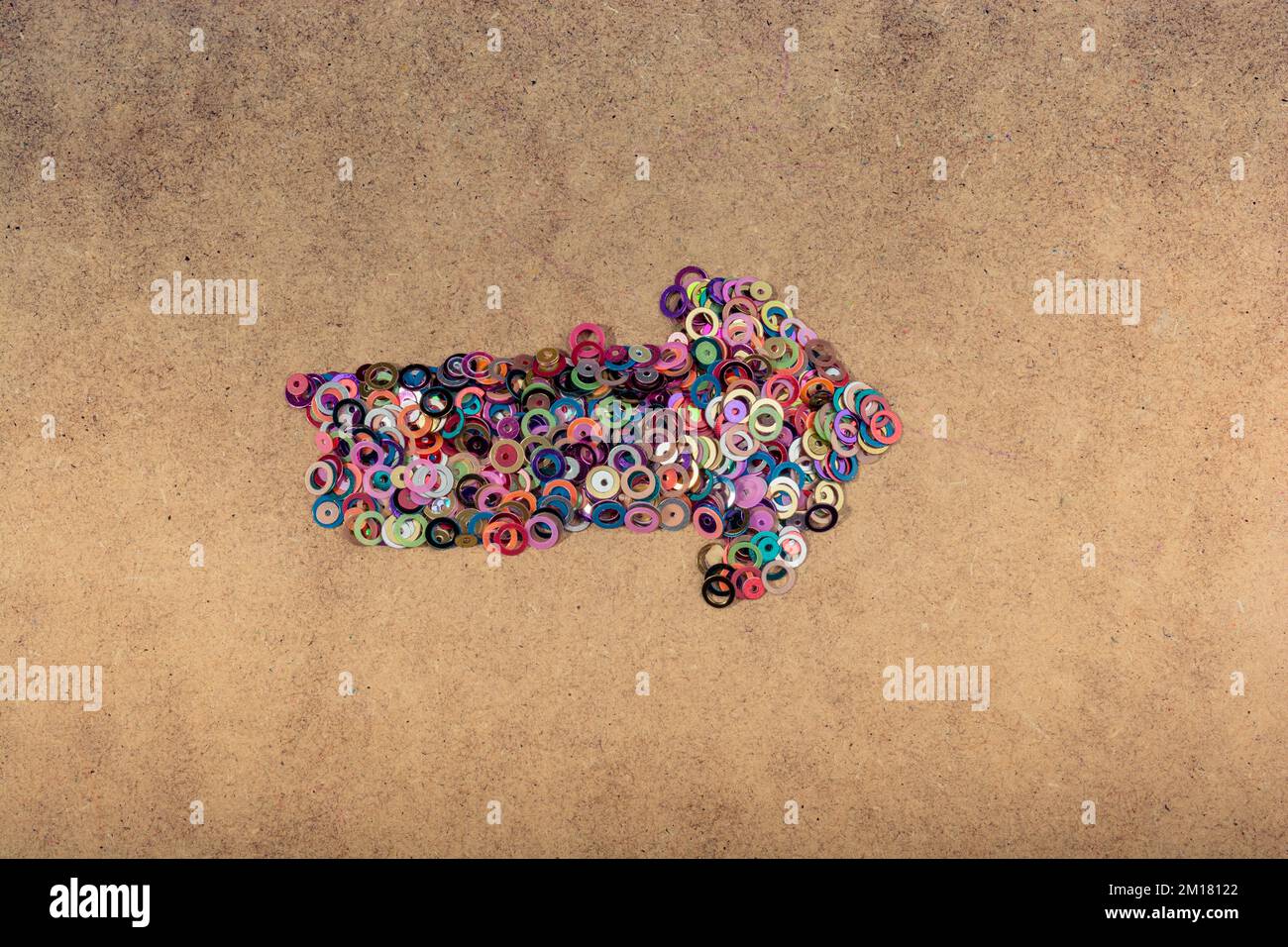 Arrow shape formed out of tiny bright colorful objects Stock Photo - Alamy