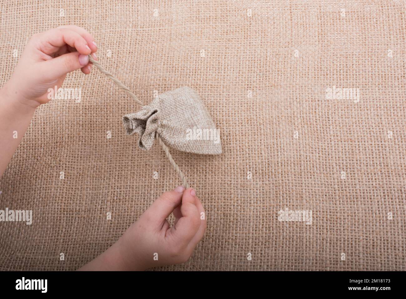 Hand holding an empty little sack made of linen Stock Photo - Alamy