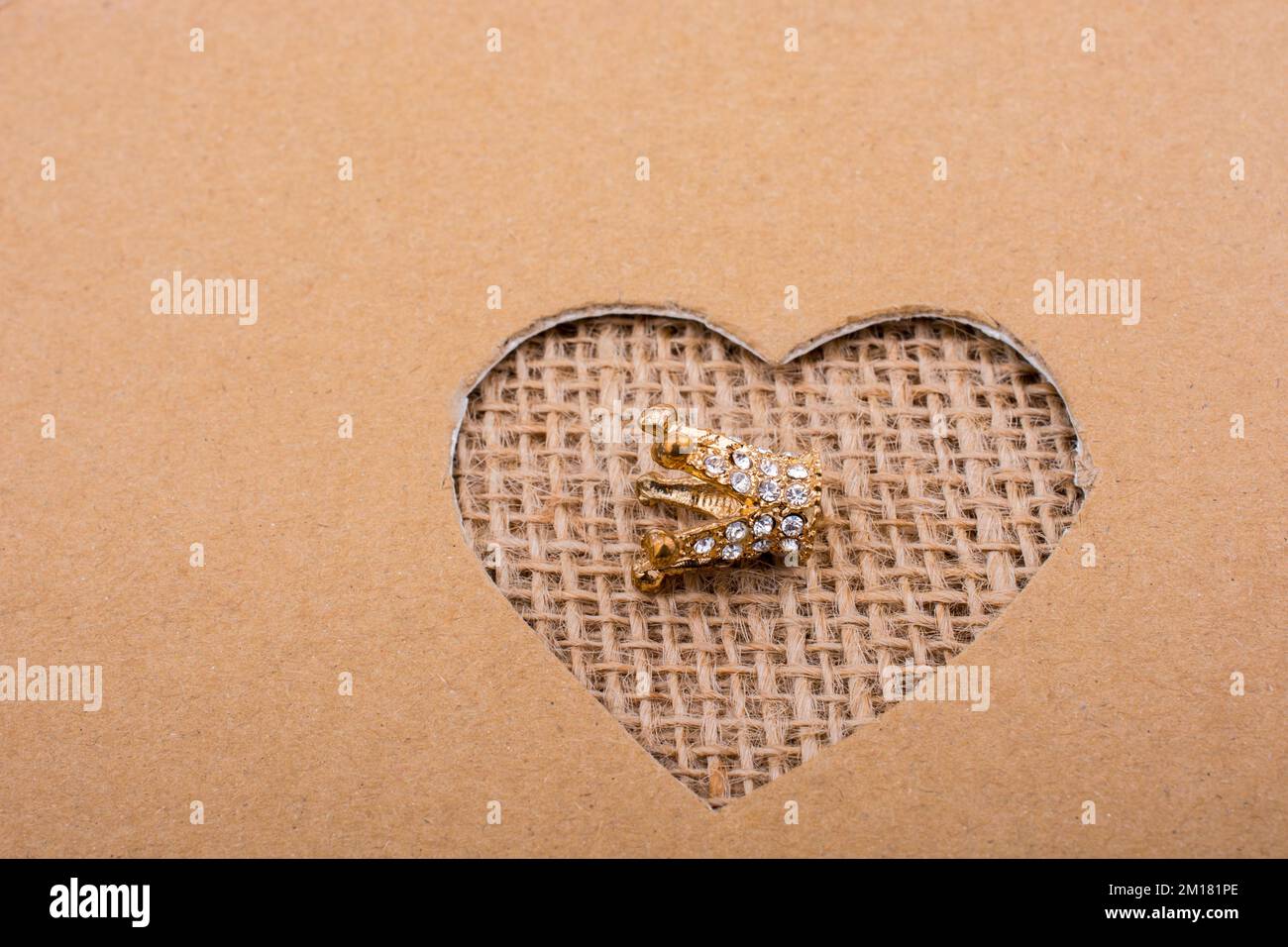 Crown seen through heart shape cut out of cardboard Stock Photo - Alamy