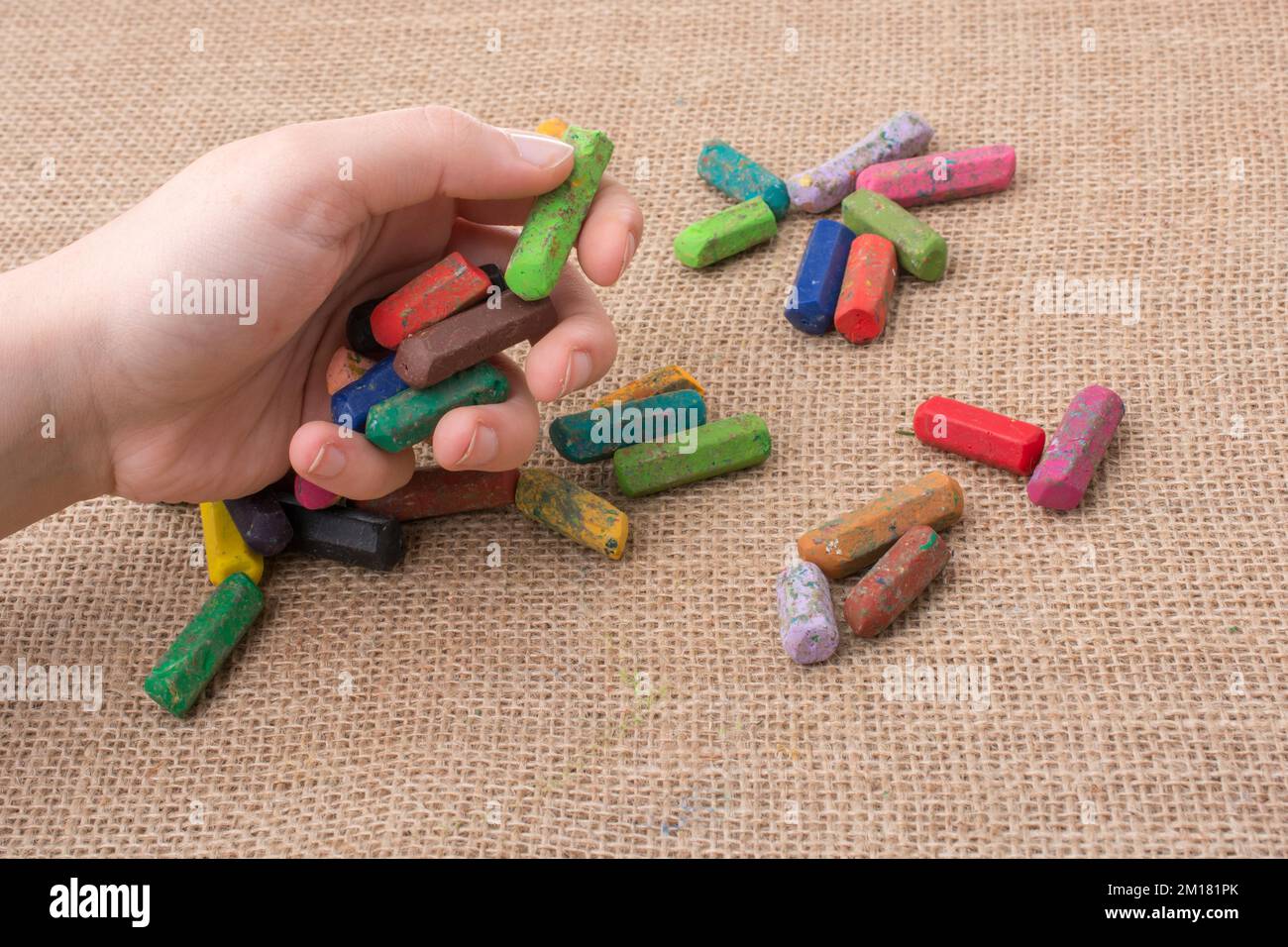 Used color crayons and a hand holding some Stock Photo - Alamy