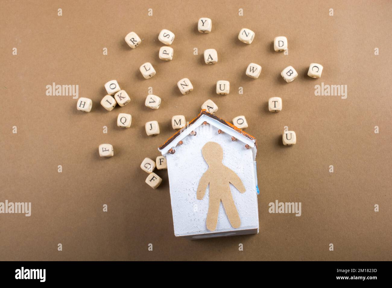Wooden letter cubes and man figurine and model house Stock Photo - Alamy