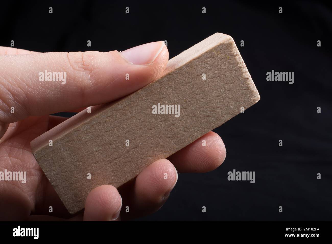 Small piece of cut wood in hand background Stock Photo - Alamy