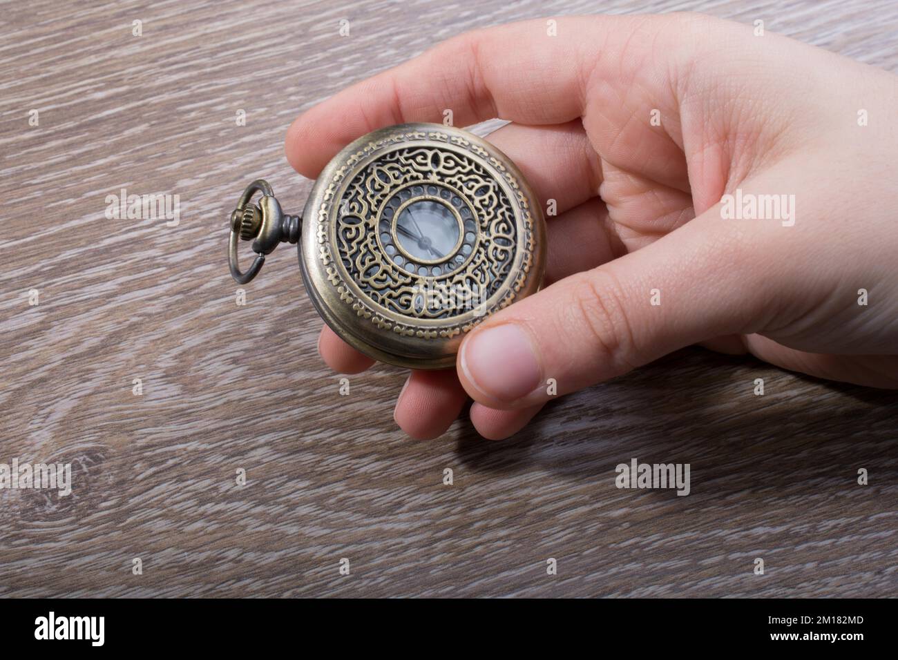 Retro style pocket watch in hand on black background Stock Photo - Alamy