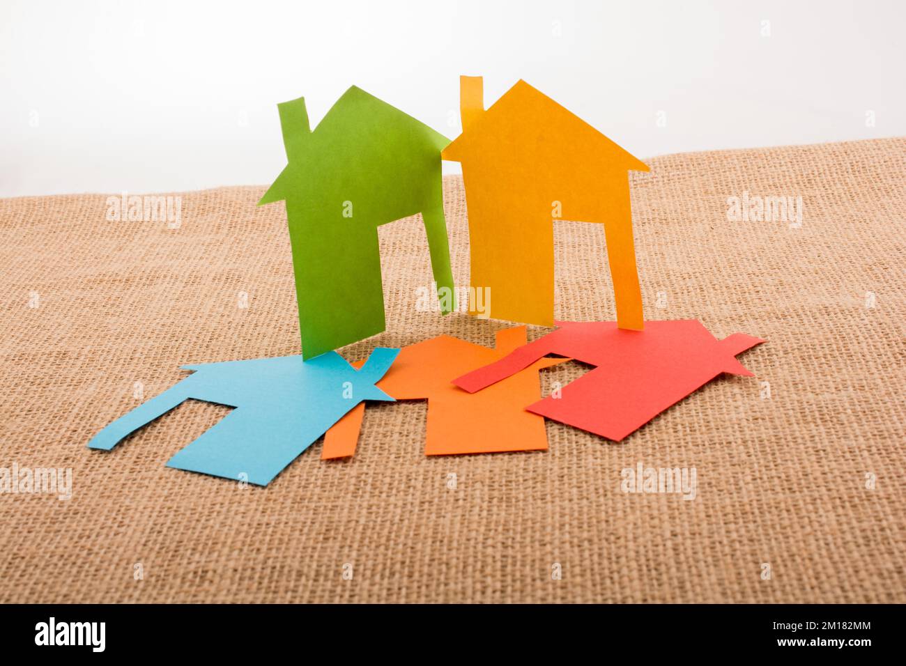 Little house shape cut out of colorful paper on a canvas background ...