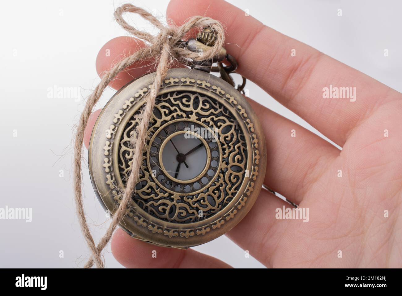 Retro style pocket watch in hand on white background Stock Photo - Alamy