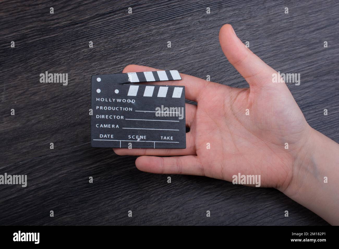 Hand holding movie clapper on a dark background Stock Photo - Alamy