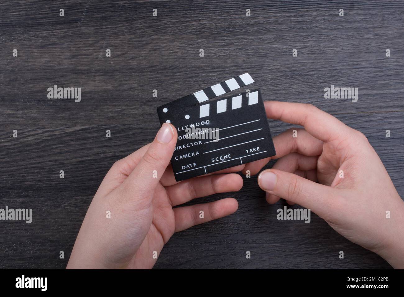 Hand holding movie clapper on a dark background Stock Photo - Alamy