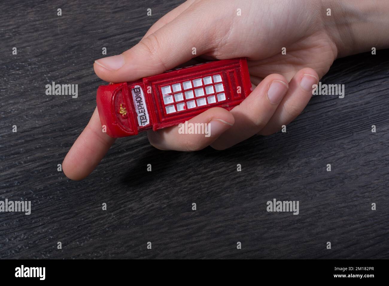Hand holding a phone booth on a dark background Stock Photo - Alamy
