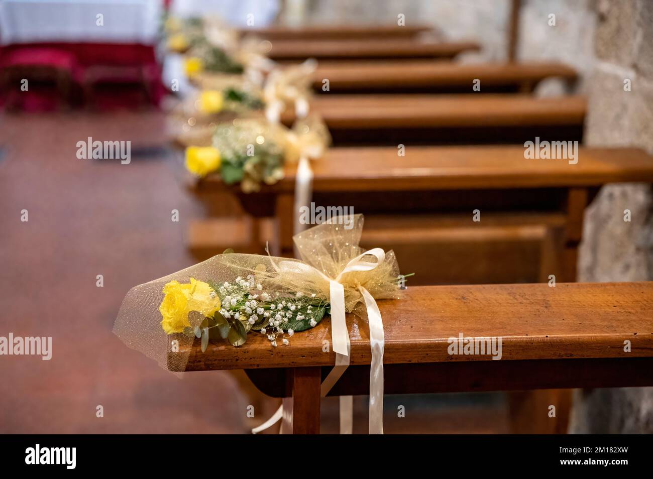 church pews decorated for a ceremony with flowers and tulle Stock Photo ...