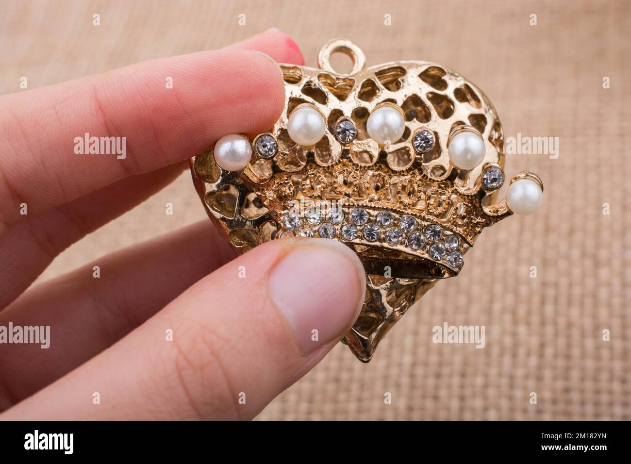 Hand holding a little model crown in hand Stock Photo - Alamy