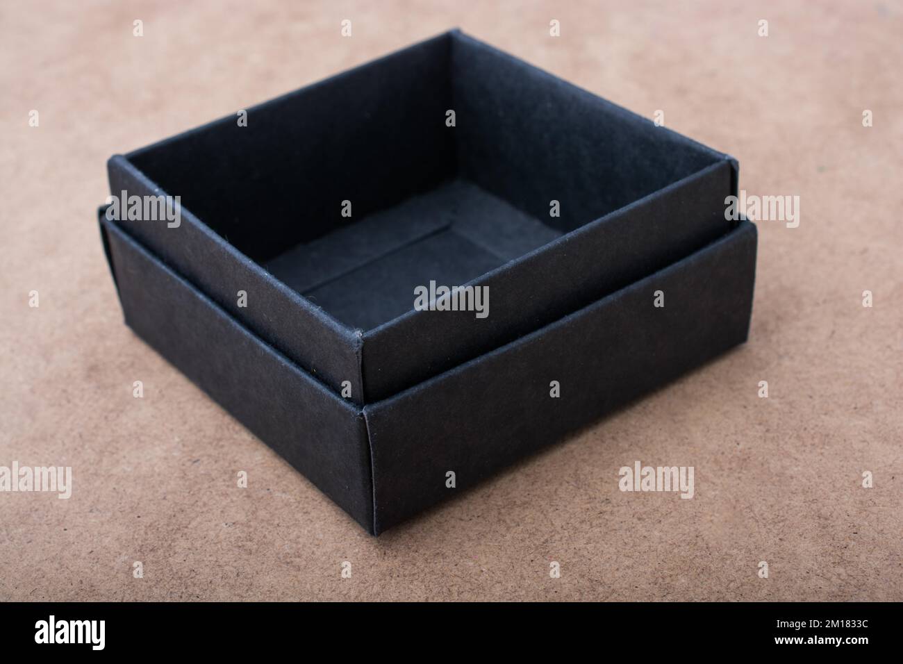 Gift box of black color on brown background Stock Photo - Alamy