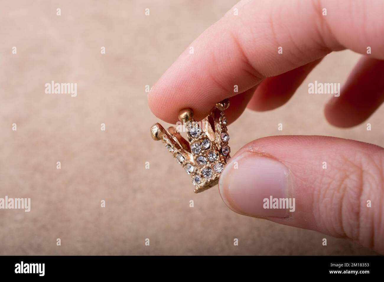 Hand holding a little model crown in hand Stock Photo - Alamy