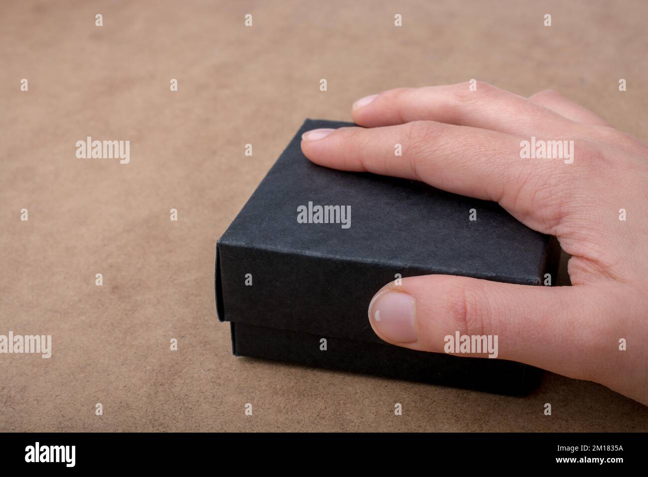 Hand holding a gift box of black color in hand Stock Photo - Alamy