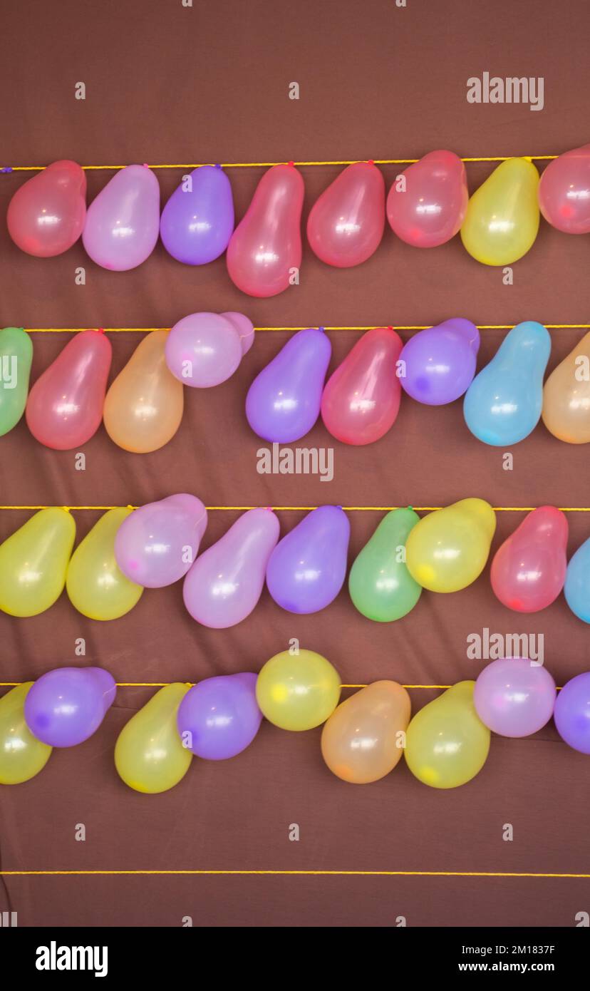 Balloon shooting game with balloons tied on a string Stock Photo - Alamy